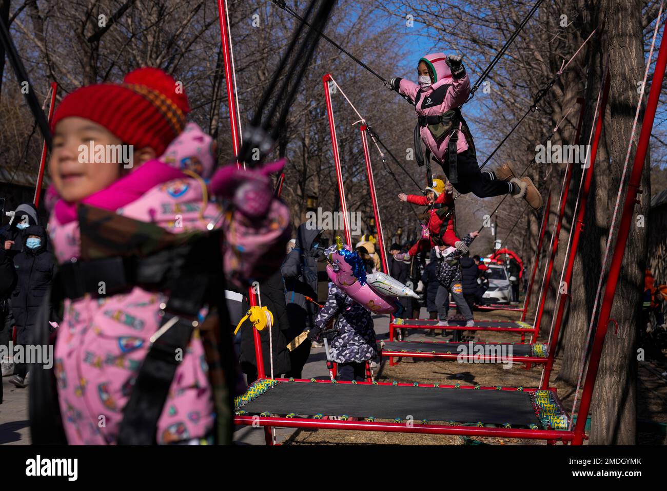 Children play trampolines as people visit a temple fair at the ...