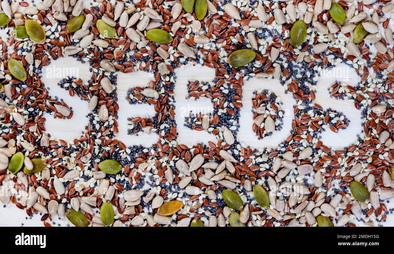 Seeds of goodness. Seeds written in a mix of health seeds on light wood Stock Photo - Alamy