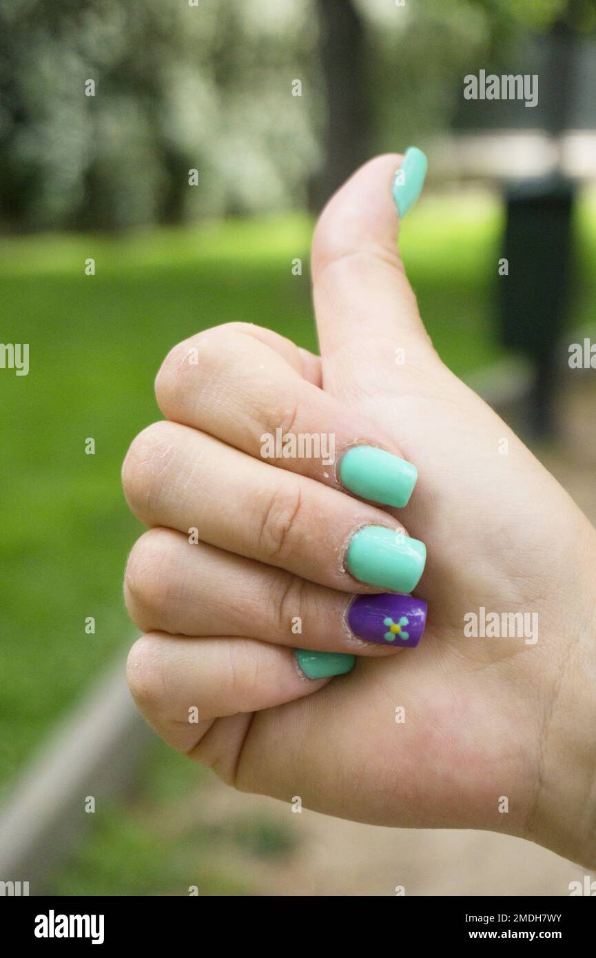 Womans hand with nails painted in green color. Green background Stock ...