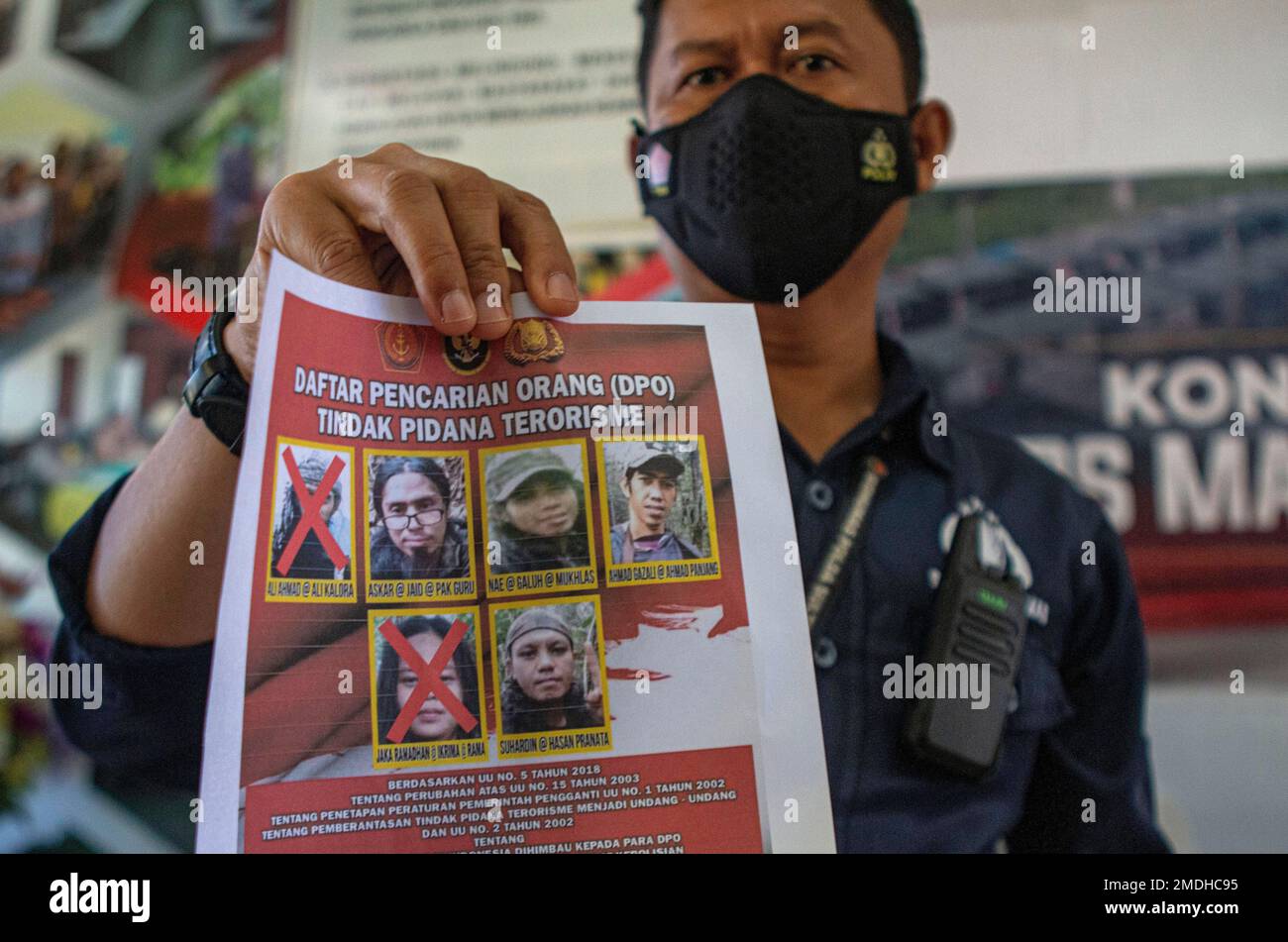 A police officer shows a wanted poster displaying the photos of two ...