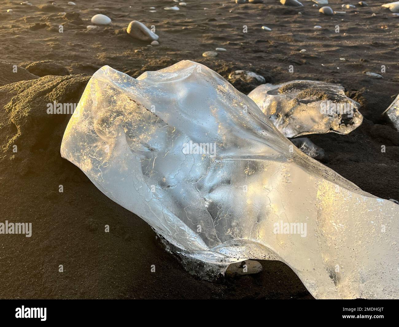 A closuep of a large piece of ice on the wet sandy ground Stock Photo ...