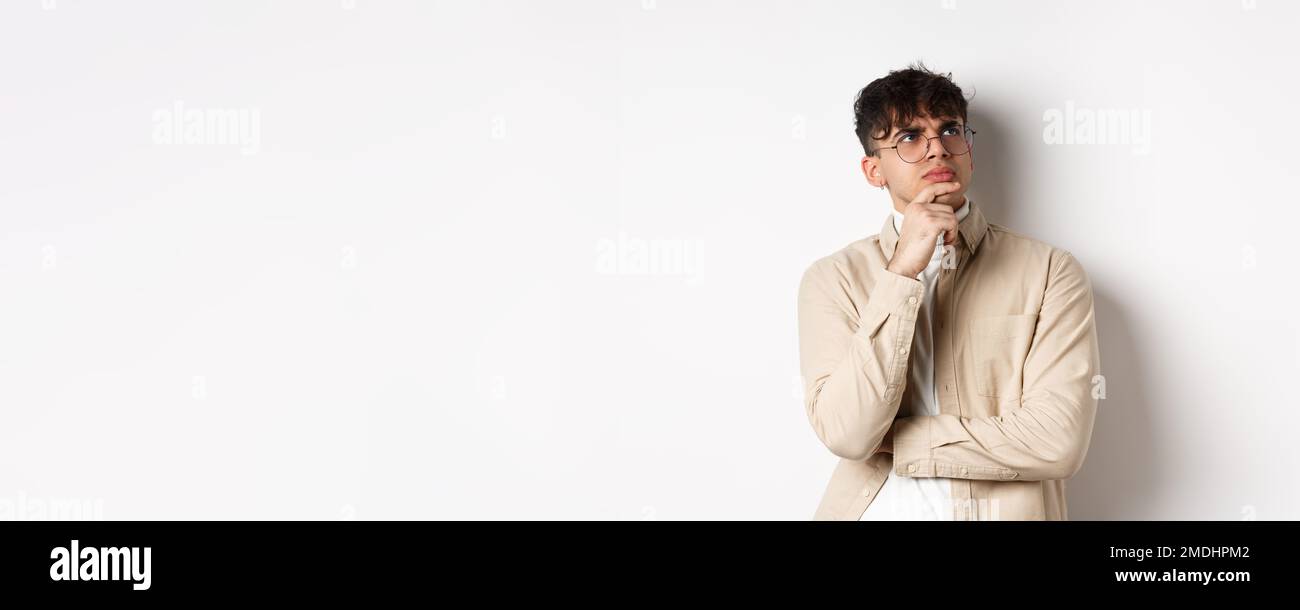 Handsome hipster guy in glasses look pensive at empty space, touching ...