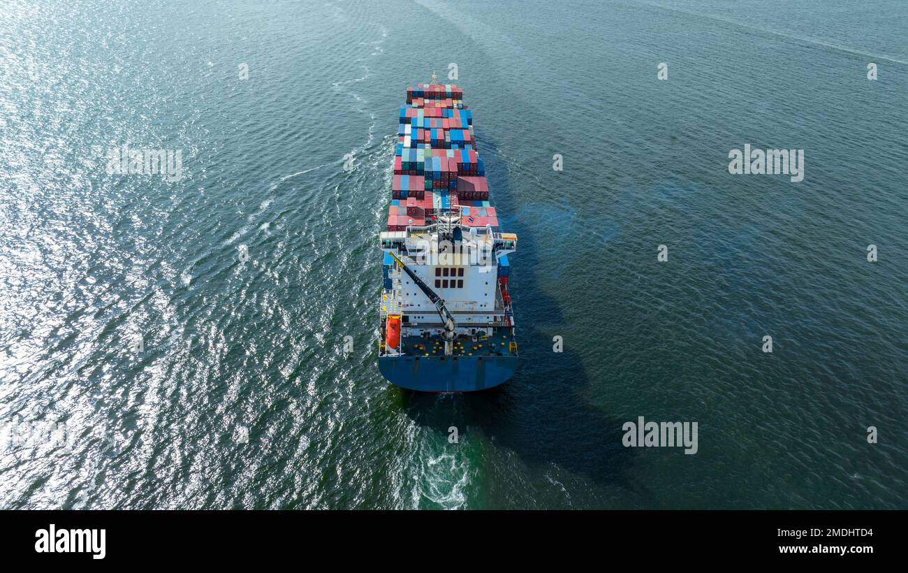 cargo maritime ship with contrail in the ocean ship carrying container ...