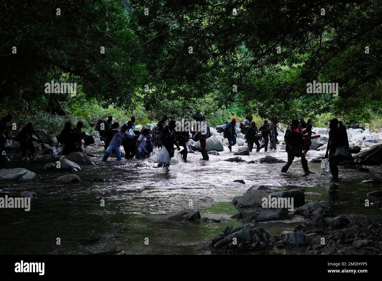 Migrants cross the Acandi River as they continue on their trek north ...