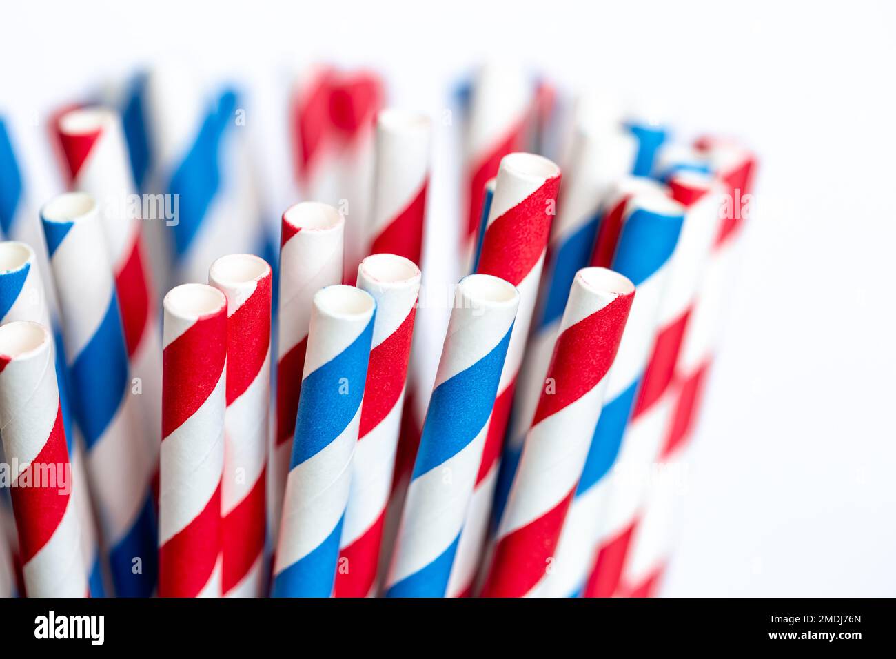 Multi-colored paper straws for drinks close-up on a white background ...