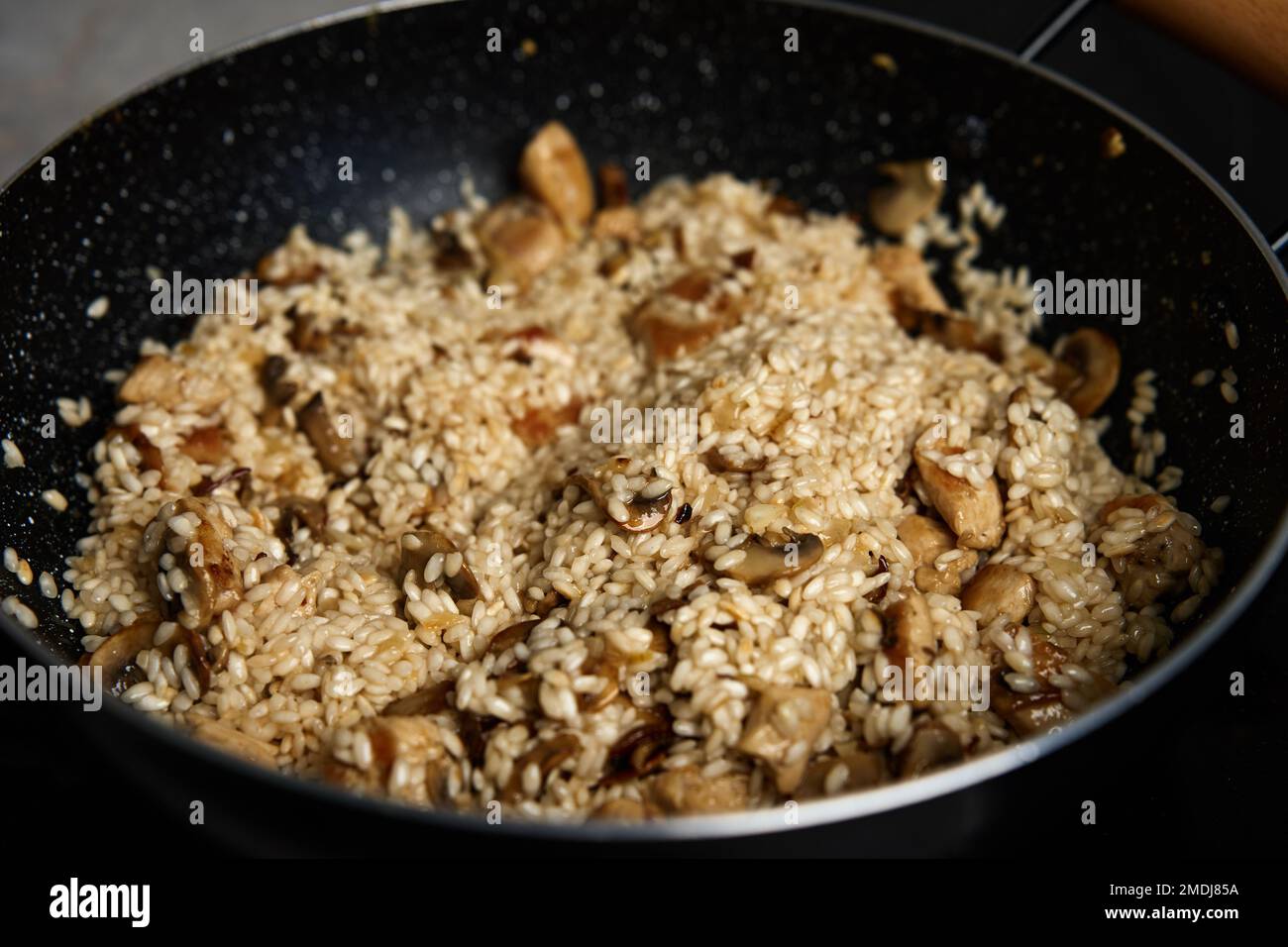 Process of cooking risotto. Arborio rice in frying pan at home kitchen ...