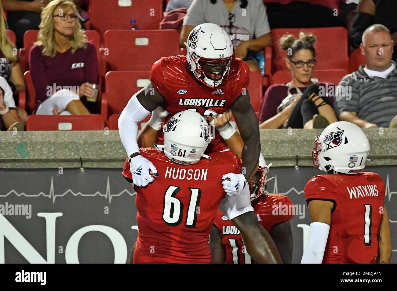 Louisville defensive back Benjamin Perry (10) is held up by offensive ...