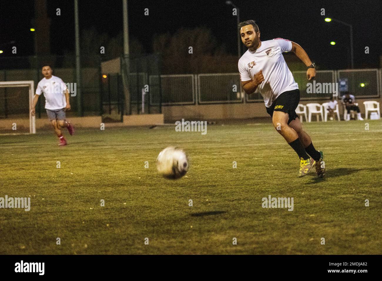 A U.S. service member runs with the ball during a soccer match at ...
