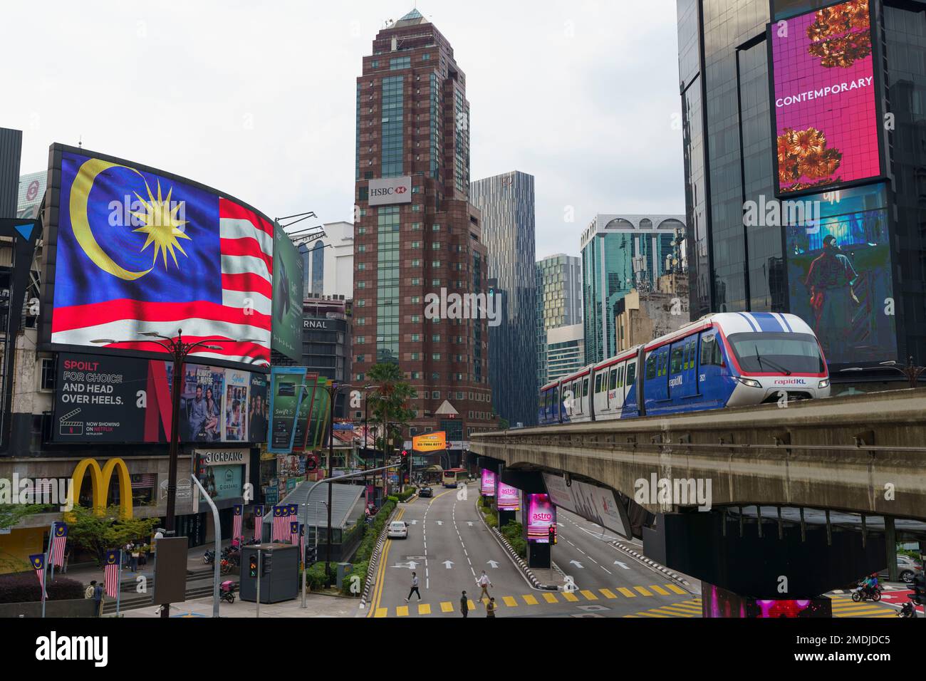 An LRT (Light Rain Transit) passes by a National flag signboard in ...