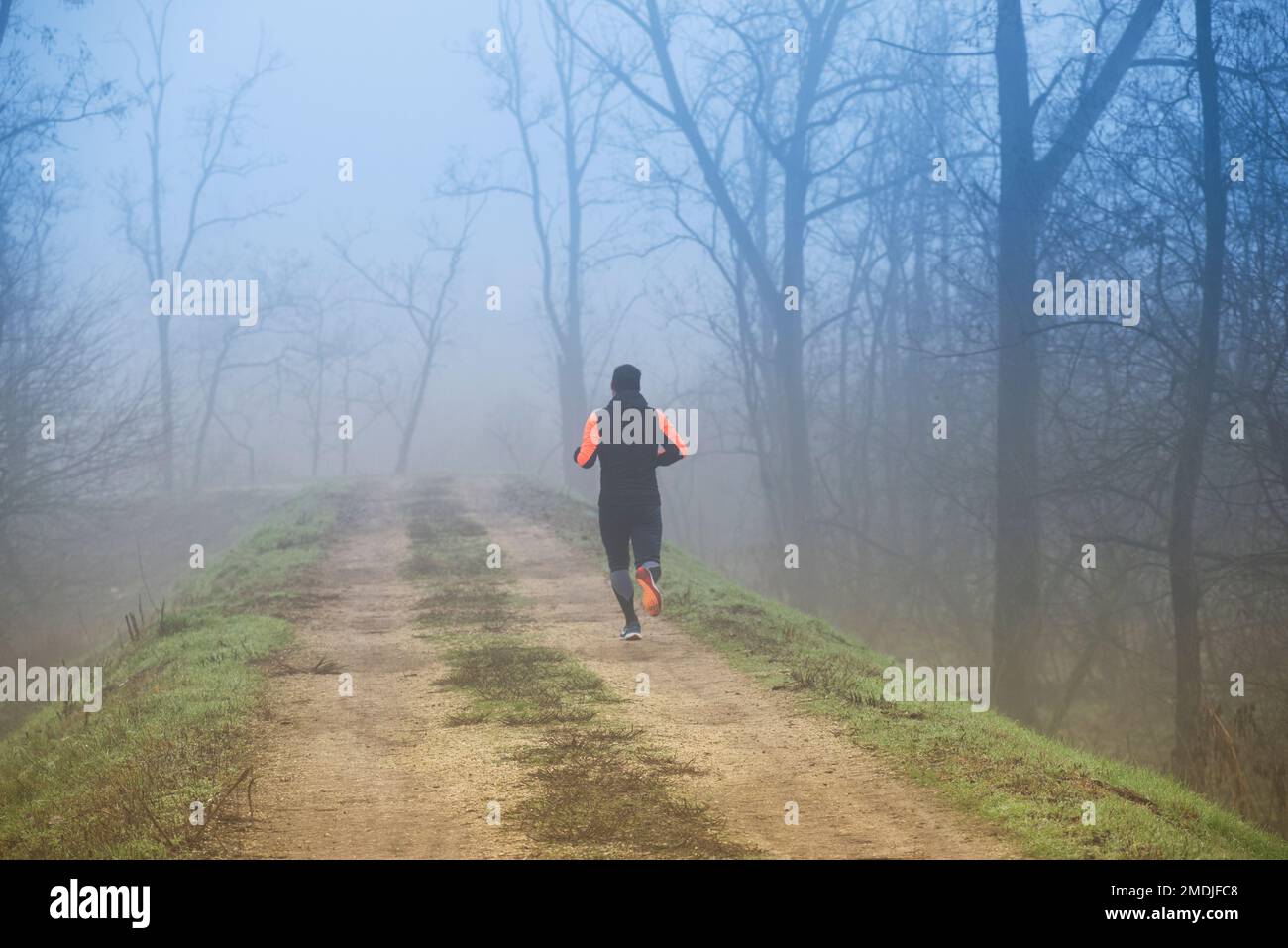 Italy, Lombardy, Man Running on Man on the Foggy Stock Photo - Alamy