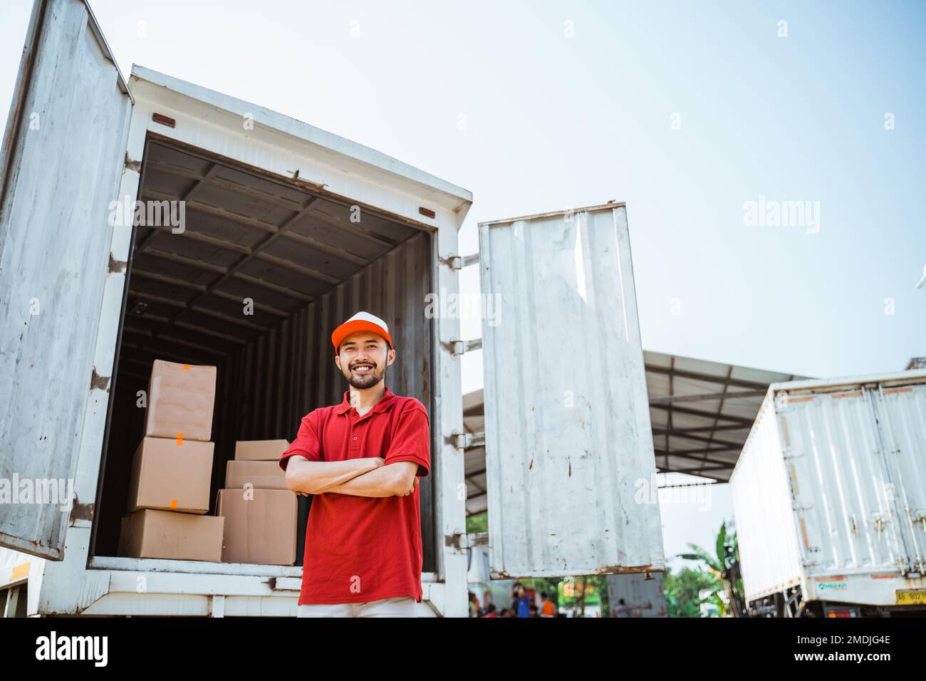 warehouse workers with arms crossed in front of containers Stock Photo ...
