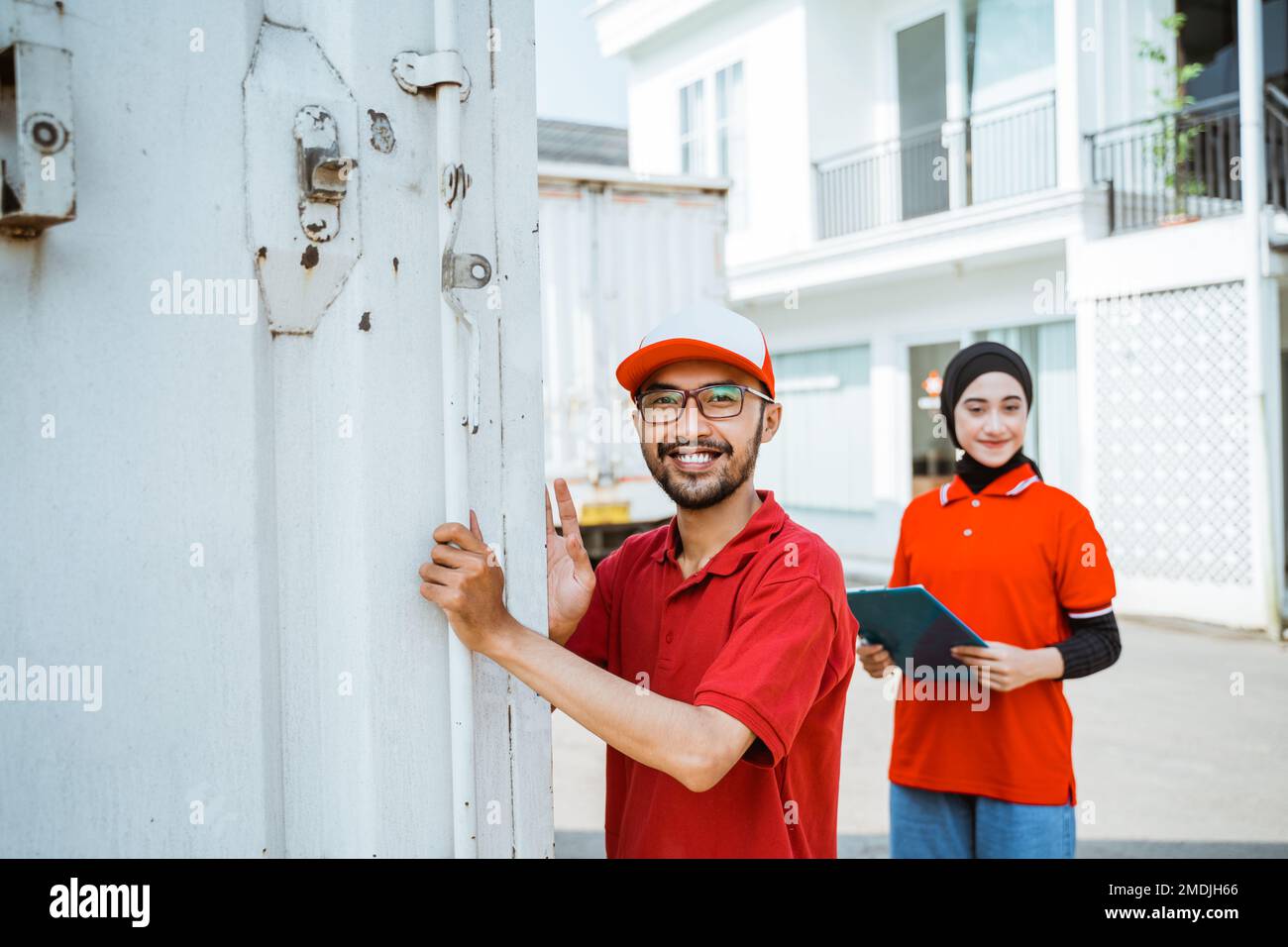 delivery man closing container door against background smiling female ...