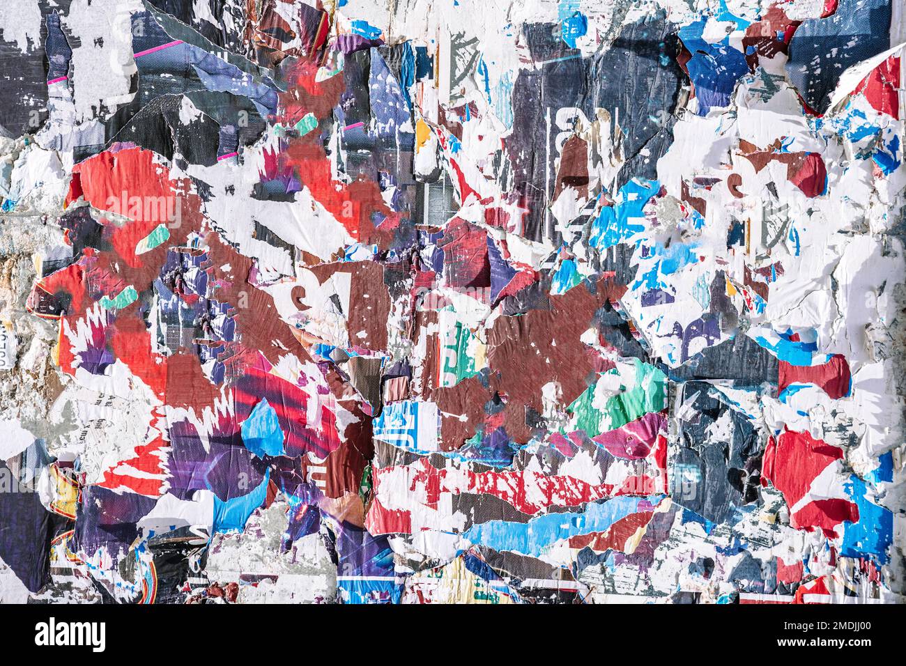 Torn paper collage background on an old poster on a street wall ...