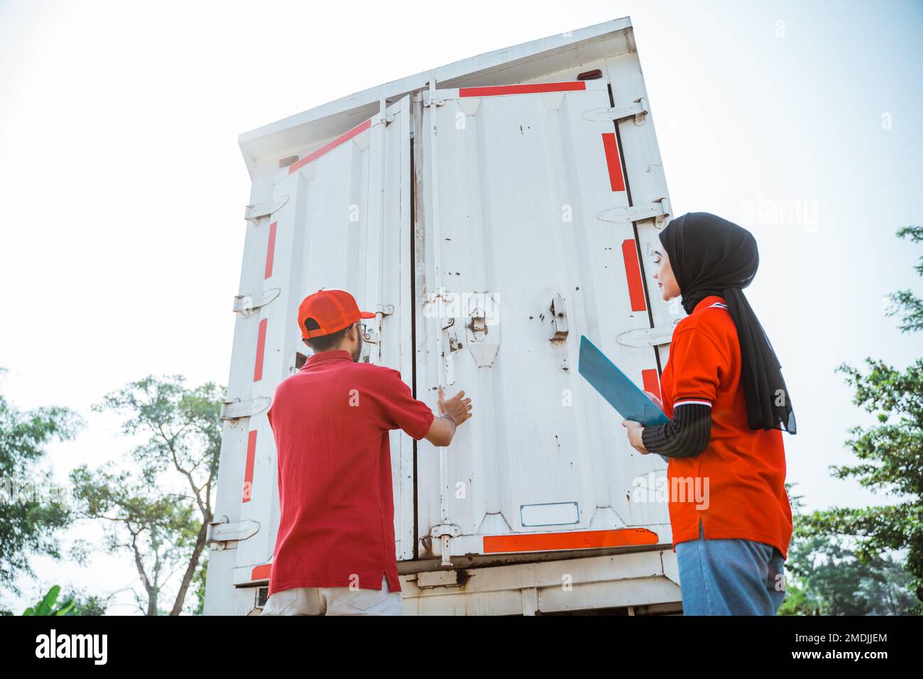 delivery man in red uniform closing the door of container Stock Photo ...