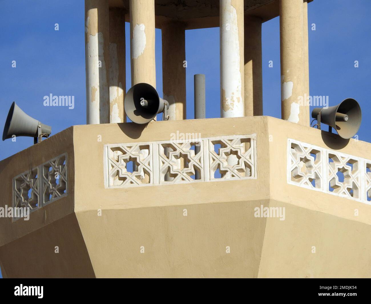 high minaret with loud speakers of a mosque against a lovely blue sky ...