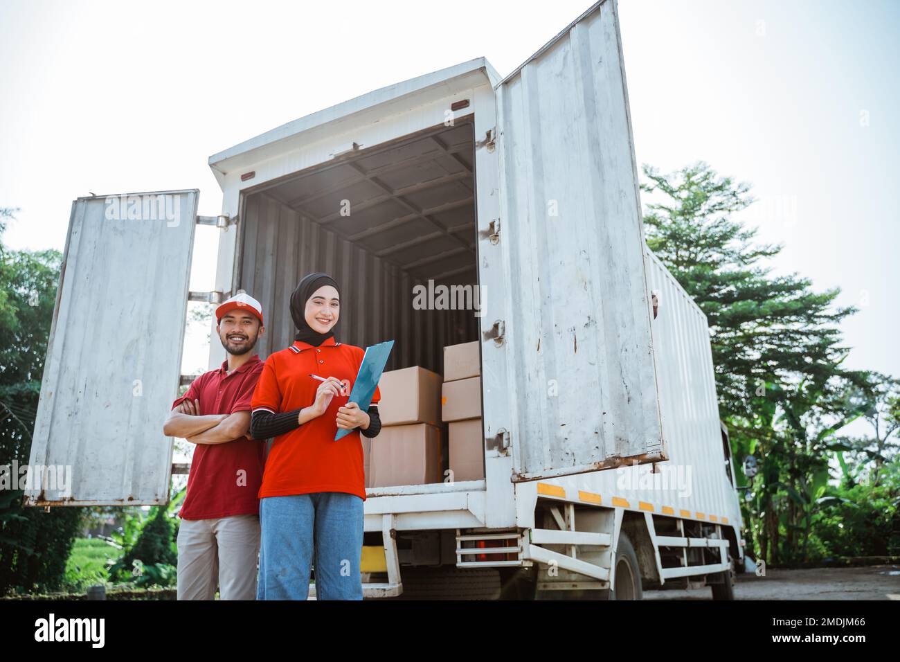 two asian workers standing behind a logistics container truck Stock ...