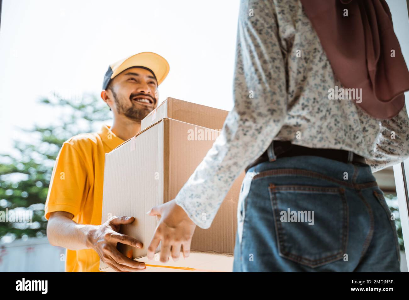 delivery man smiling friendly while delivering package boxes to ...