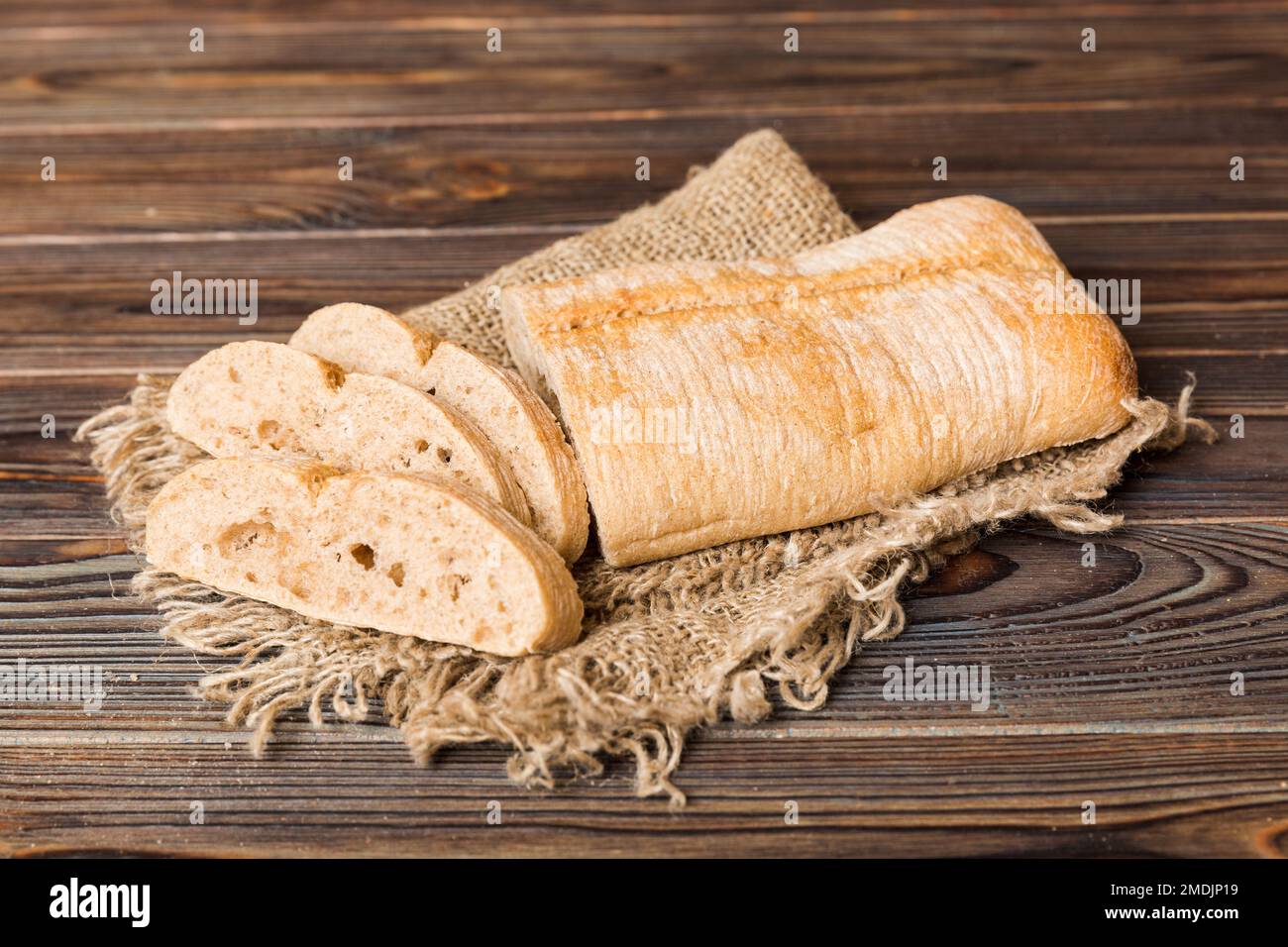 Assortment of freshly sliced baked bread with napkin on rustic table ...