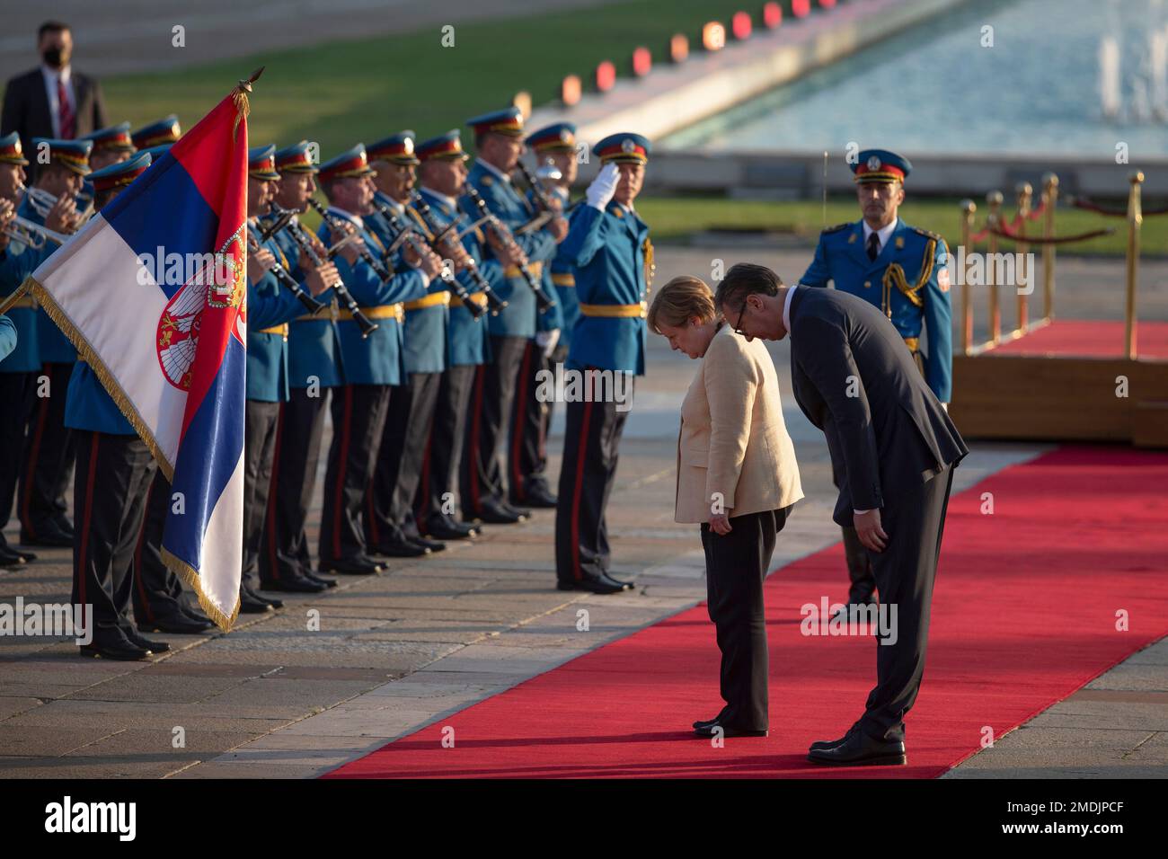 German Chancellor Angela Merkel, center, bows to the Serbian flag while ...