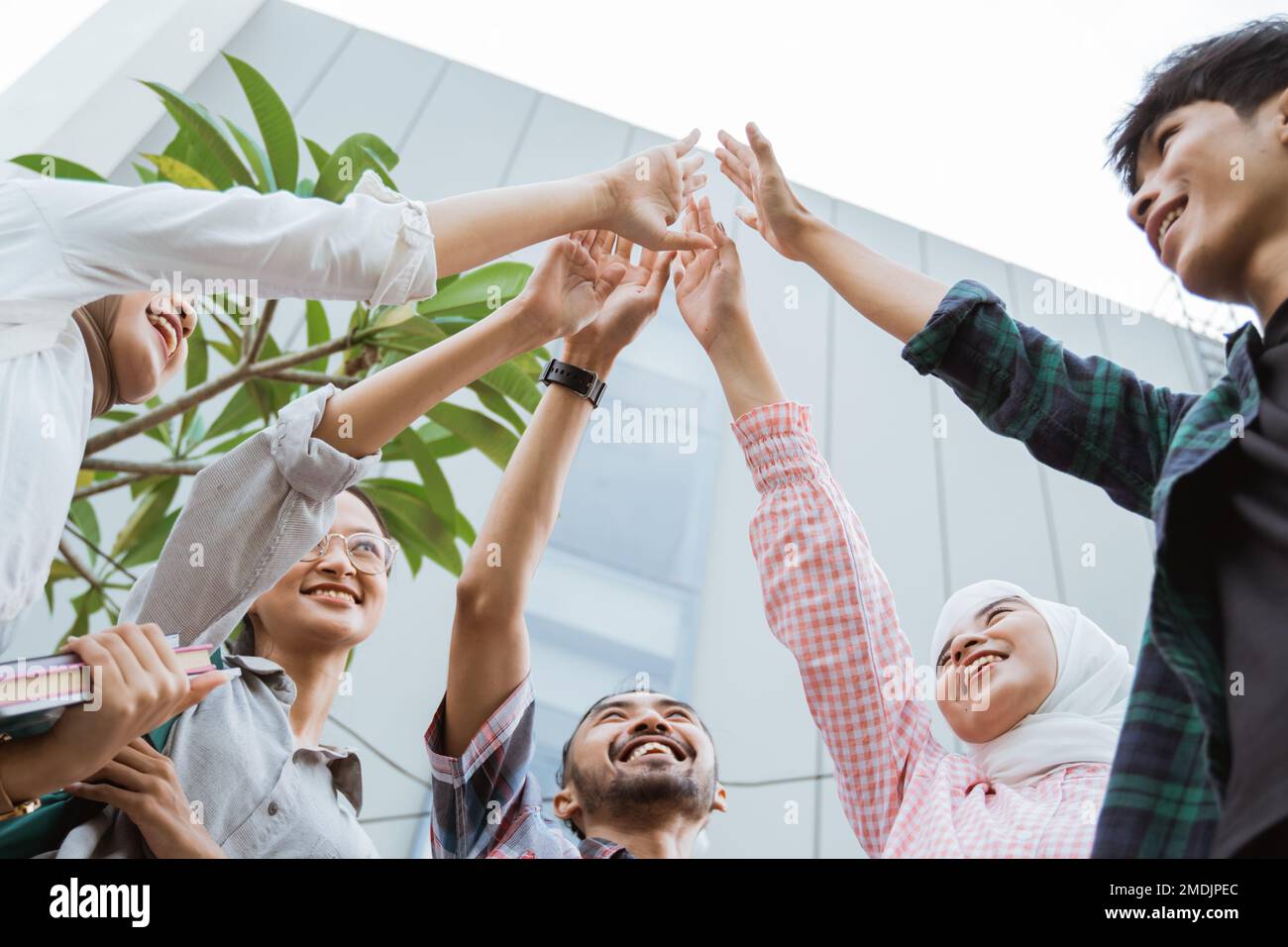 young asian people raising hands as a sign of unity Stock Photo - Alamy