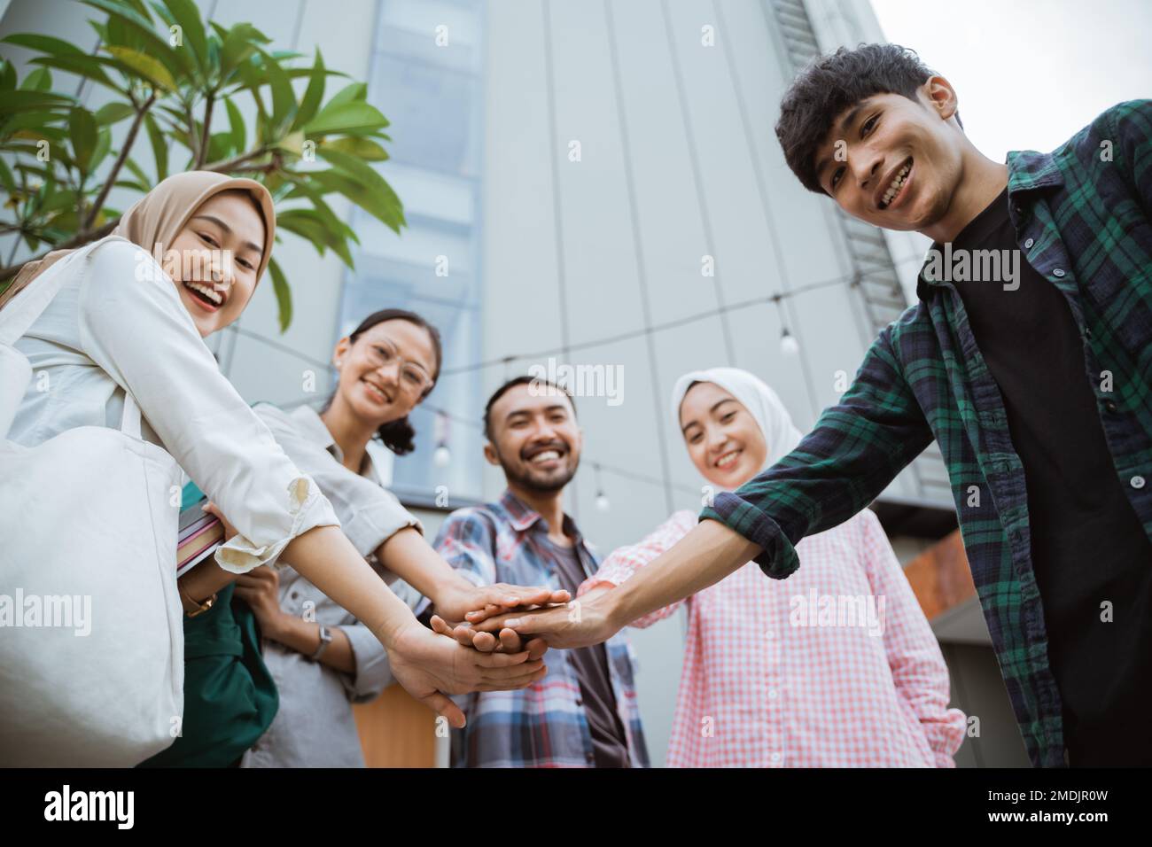 smiling students joining hands as a sign of unity Stock Photo - Alamy