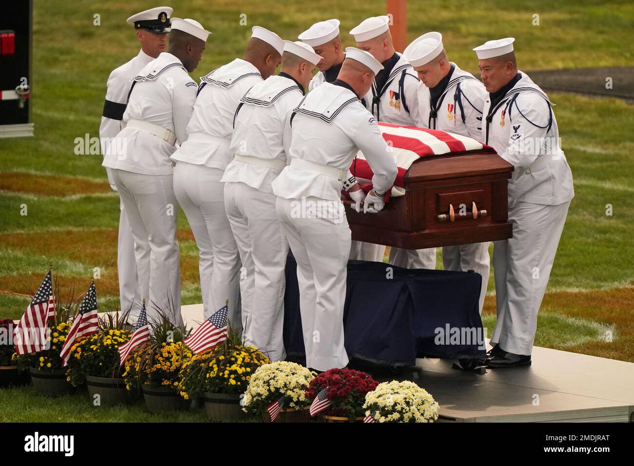 The U.S. Navy Honor Guard lower the casket of Navy Corpsman Maxton ...