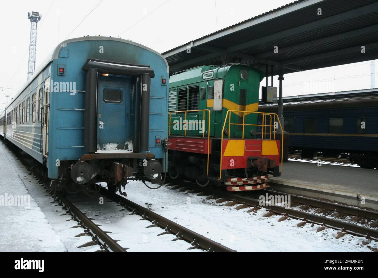 Passenger train with diesel locomotive at the station, infrastructure ...