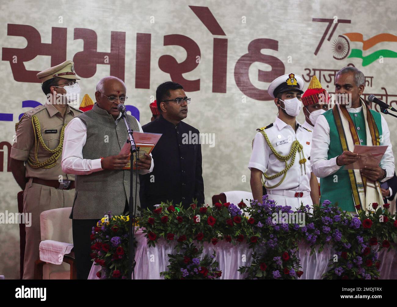 Gujarat's new chief minister Bhupendra Patel, left, takes oath during a ...