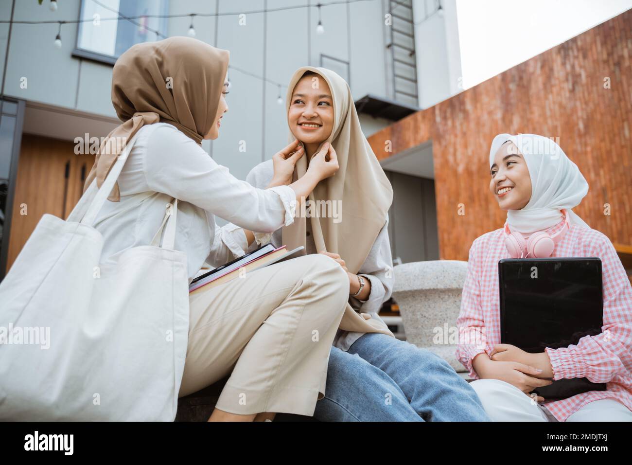 group of female students helping a friend wear a headscarf Stock Photo ...