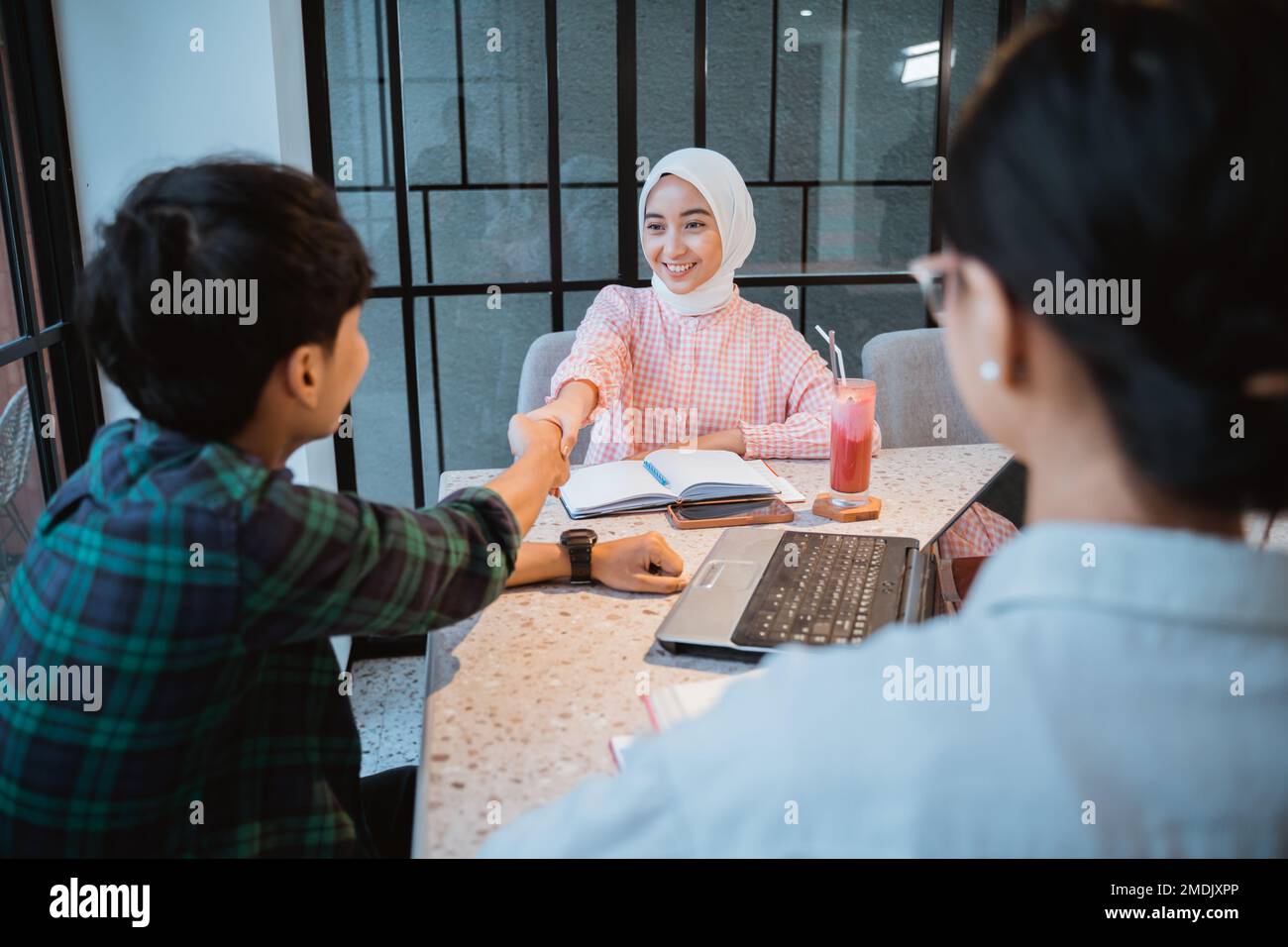 students in headscarves shake hands with male students getting ...
