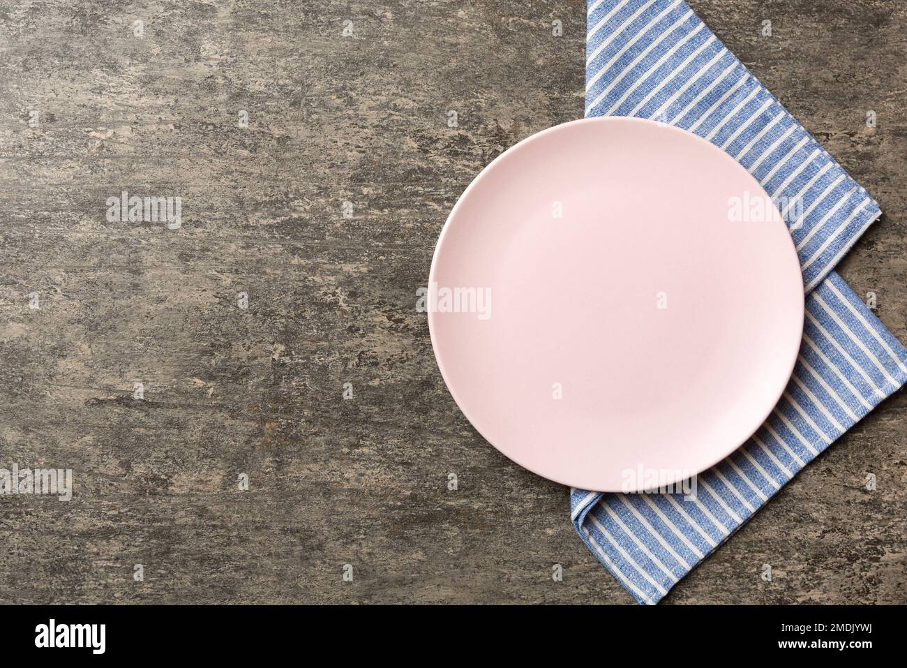 Top view on colored background empty round pink plate on tablecloth for ...