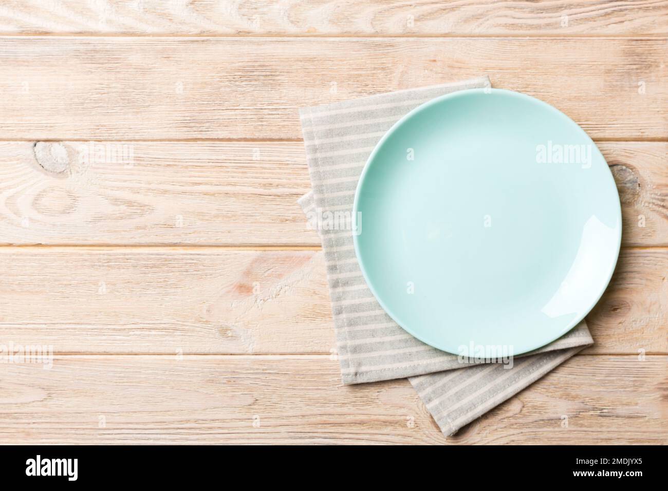 Top view on colored background empty round Blue plate on tablecloth for ...