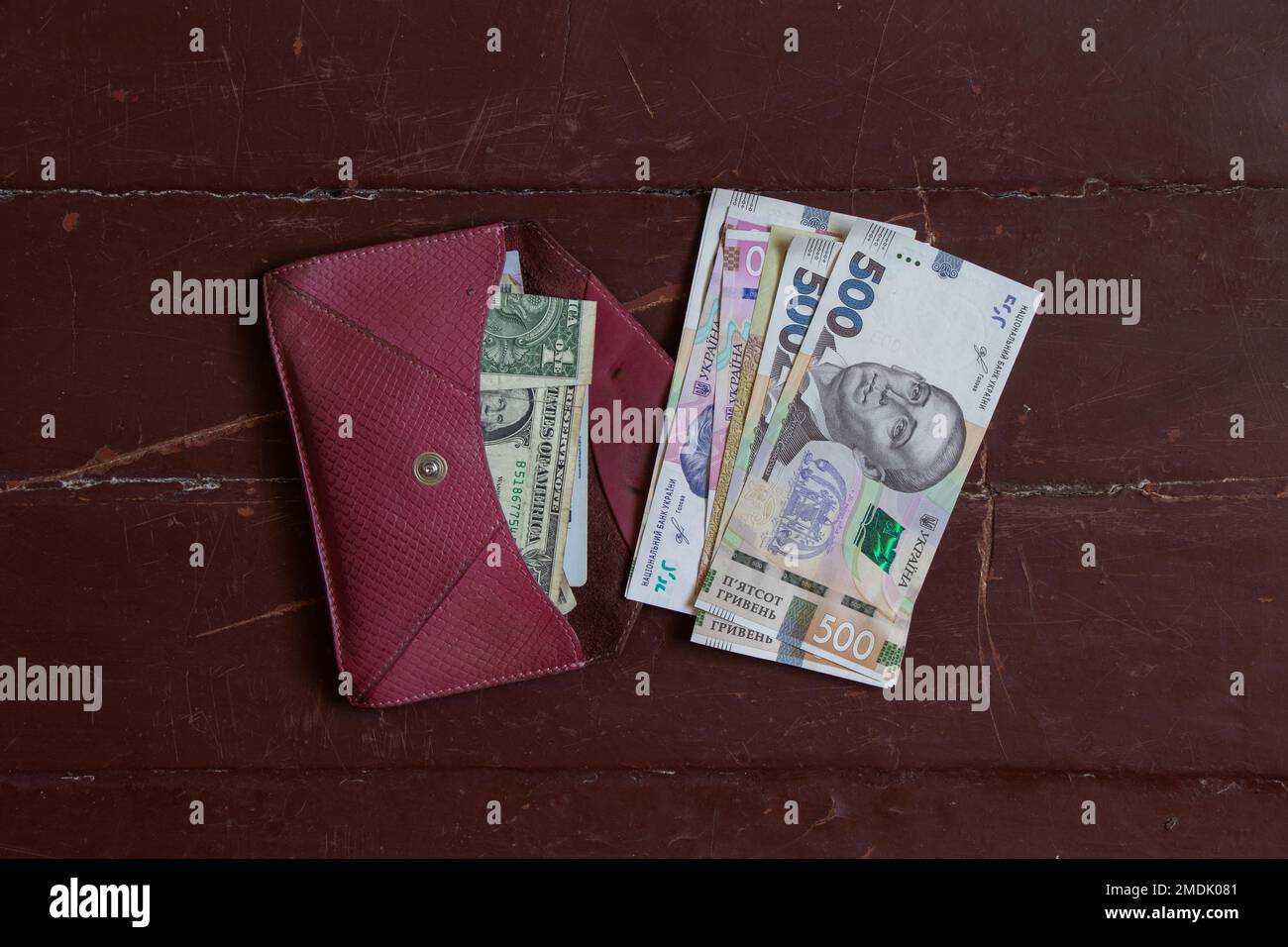 five hundred hryvnia bill lies in a red leather wallet on the table ...