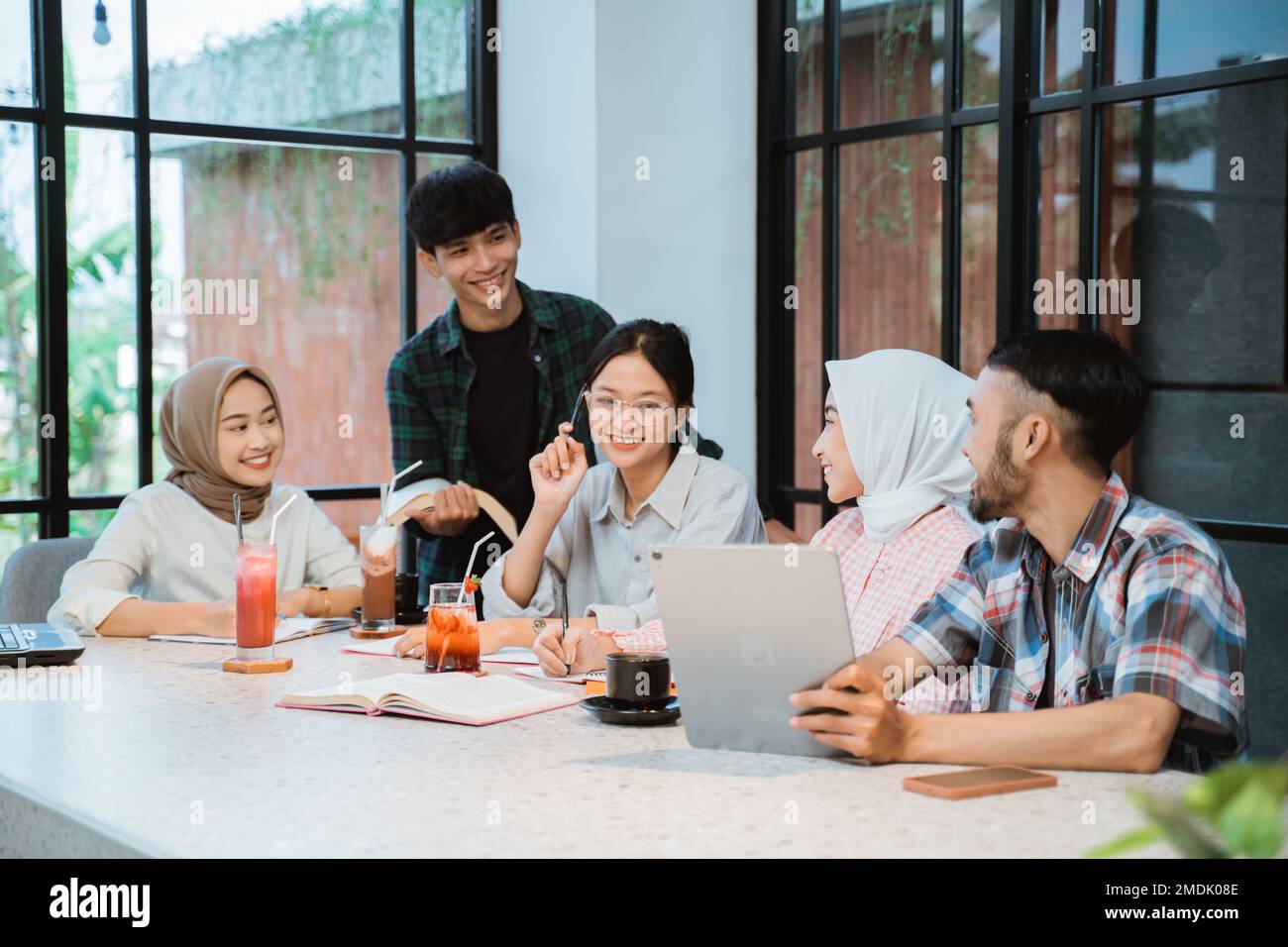 Asian young people doing homework together in cafe Stock Photo - Alamy
