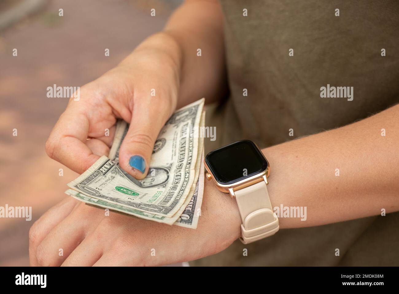 smart watch on the girl's hand took dollar bills on the street, money ...