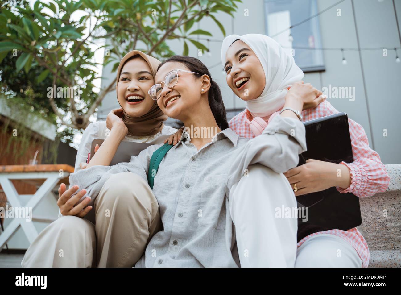 joy of three young asian people smiling while sitting together Stock ...