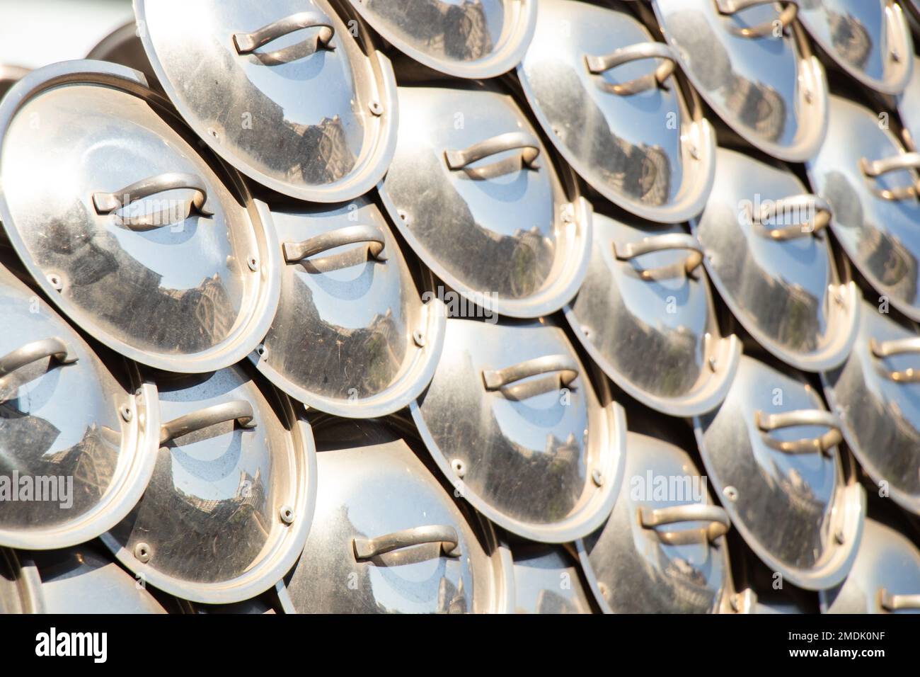 a lot of pot lids as a backdrop in the sunlight, a pot lid, kitchen ...