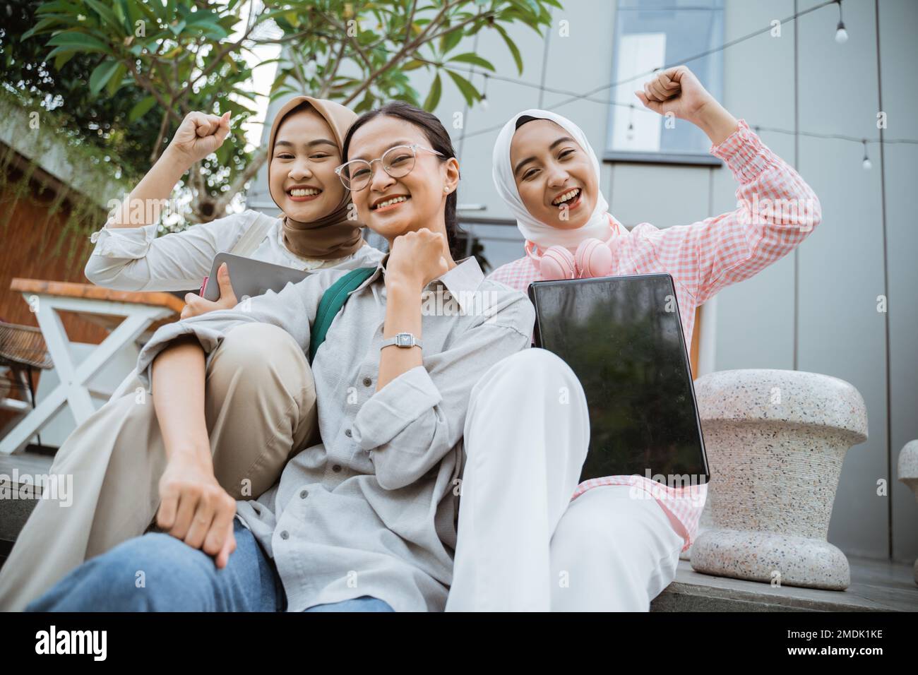 three excited girls with hand clenched gesture symbol of enthusiasm ...
