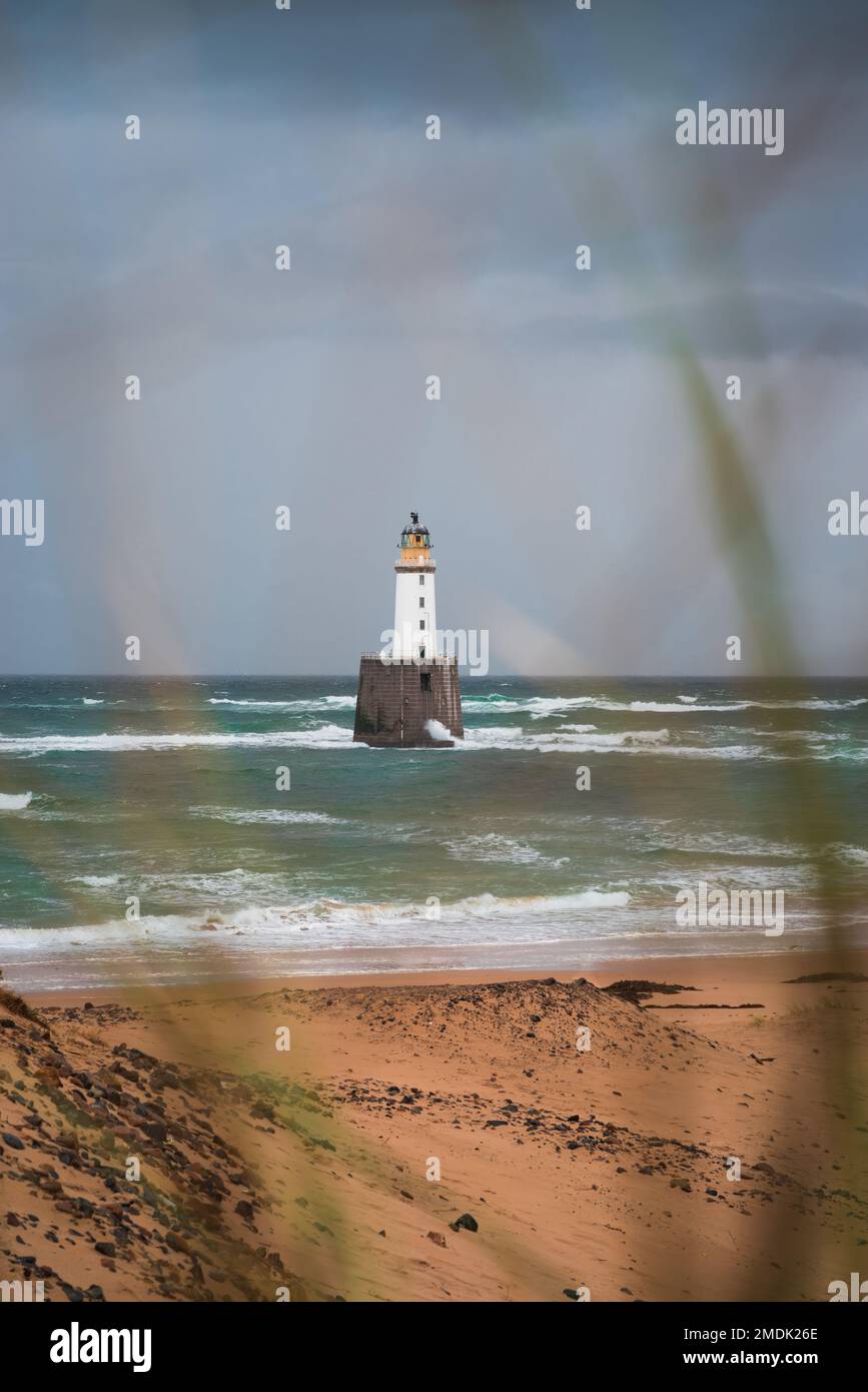 A vertical shot of the Rattray Head Lighthouse in the stormy sea with ...