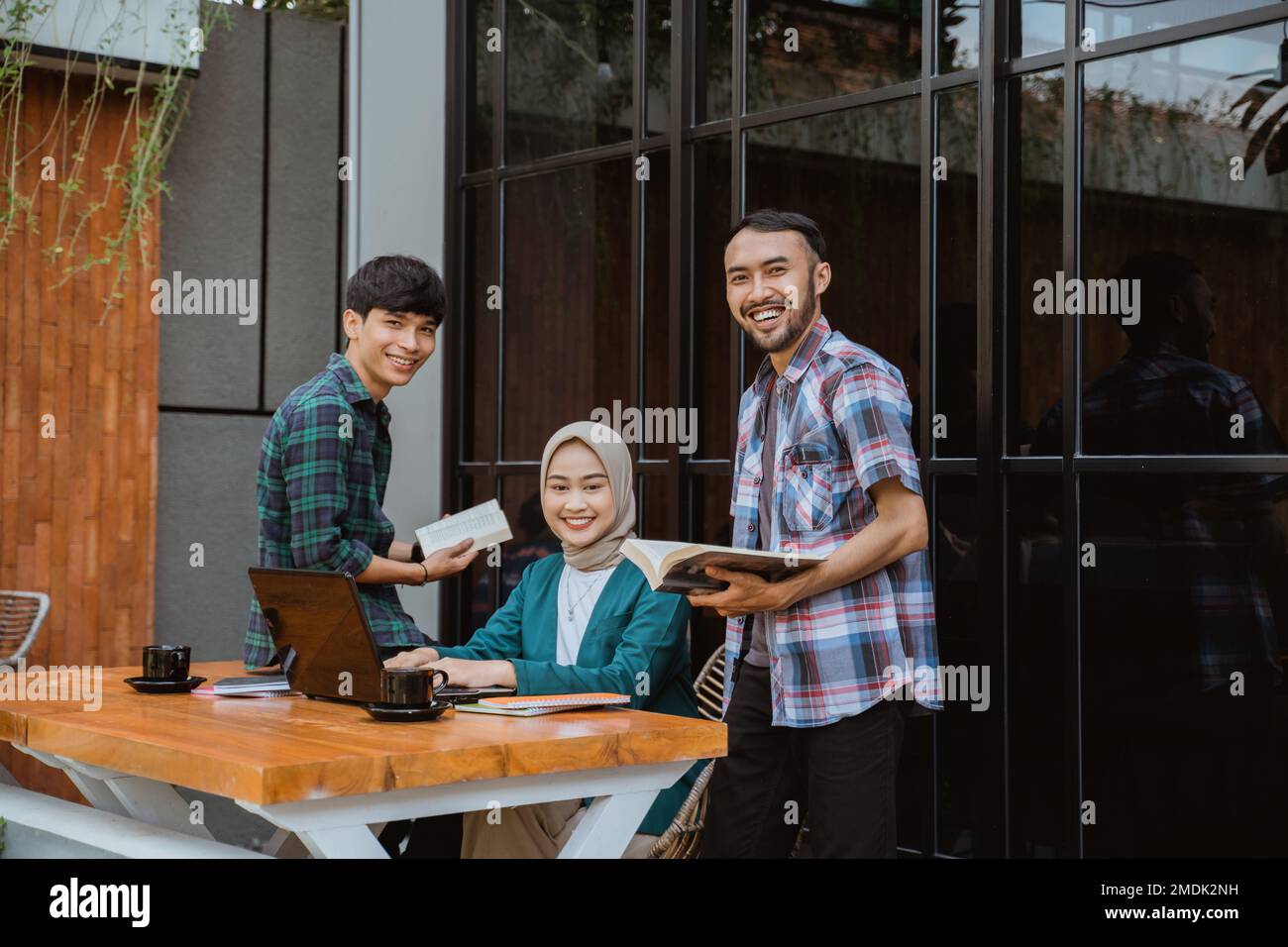 smart college students holding books while gathering Stock Photo - Alamy