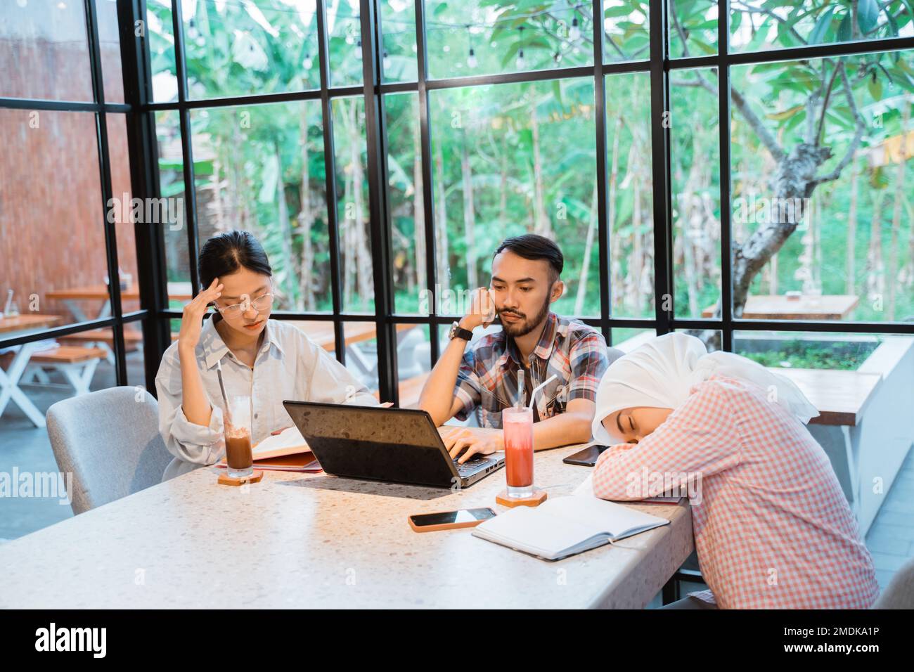 group of sad students using a laptop while working together Stock Photo ...