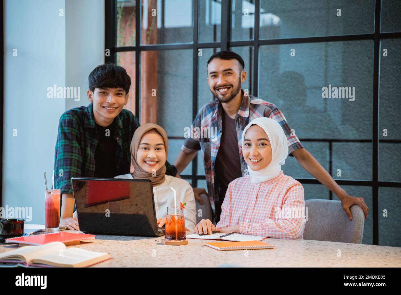 four young Asian people smiling in a cafe Stock Photo - Alamy