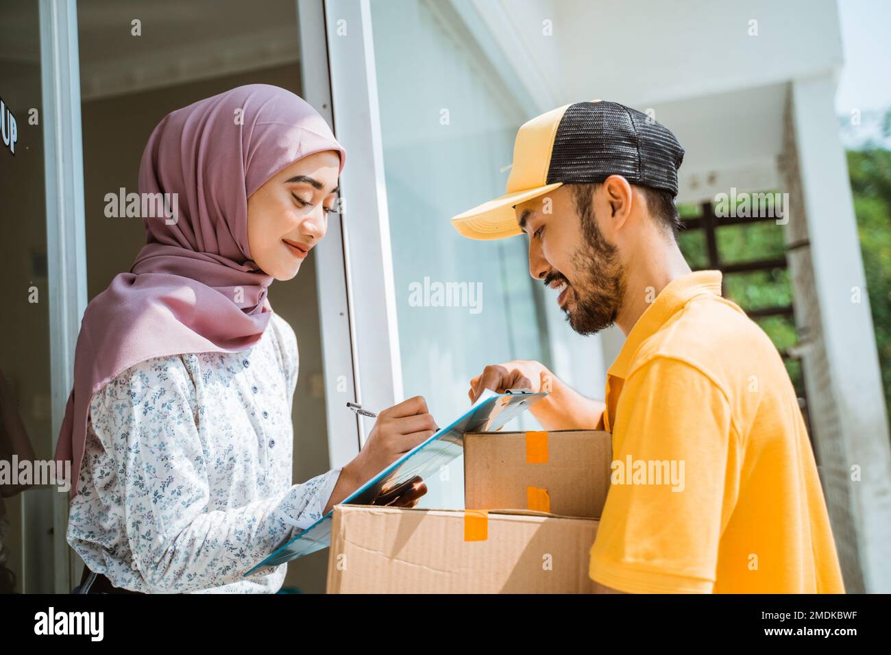 The customer signs when receiving goods from delivery men Stock Photo ...