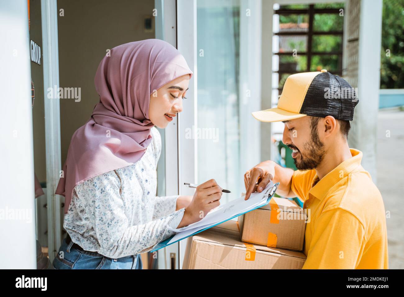 Customers fill out receipts while delivery men deliver Stock Photo - Alamy