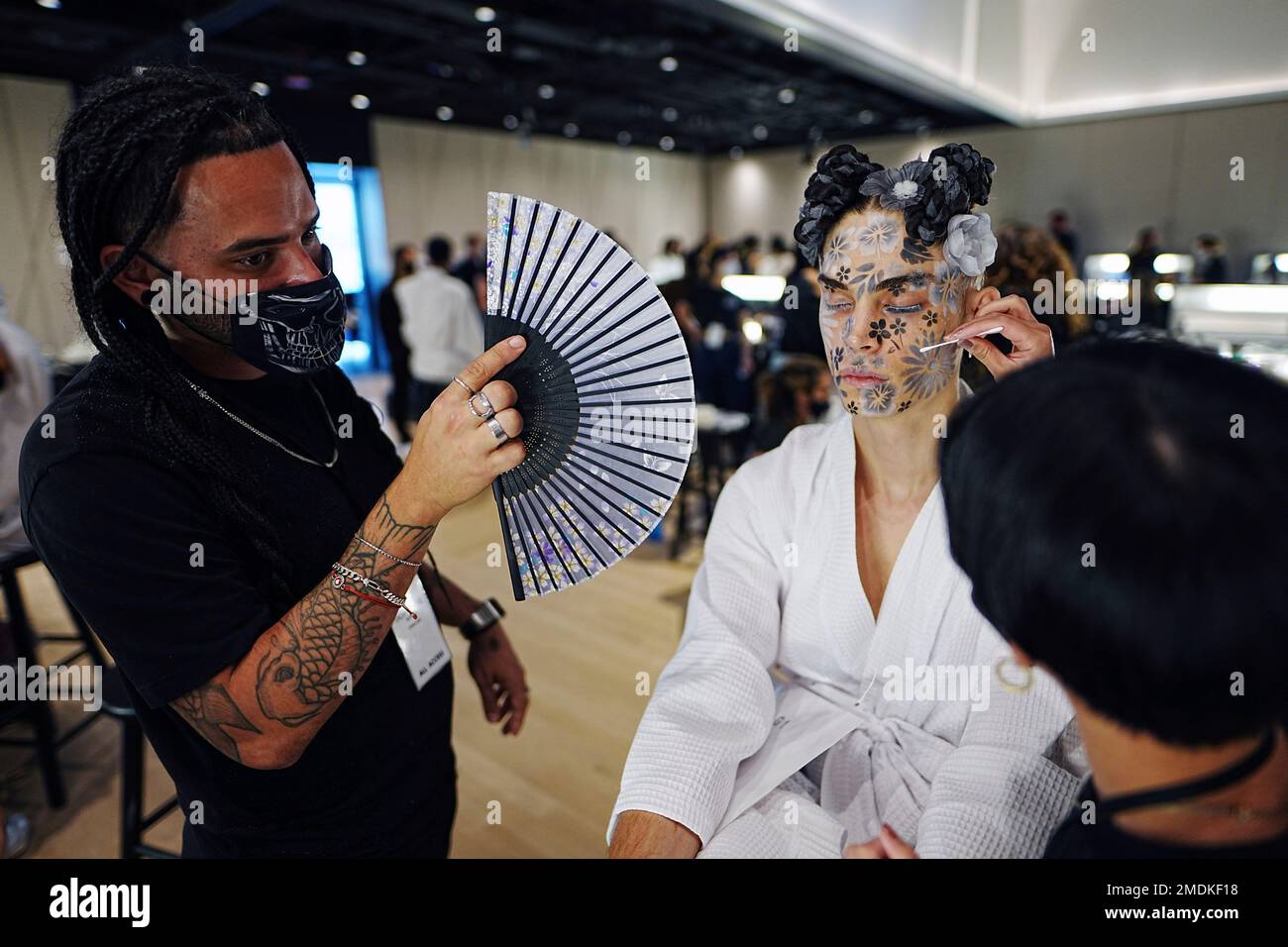 A model gets his makeup done backstage in preparation for the Thom ...