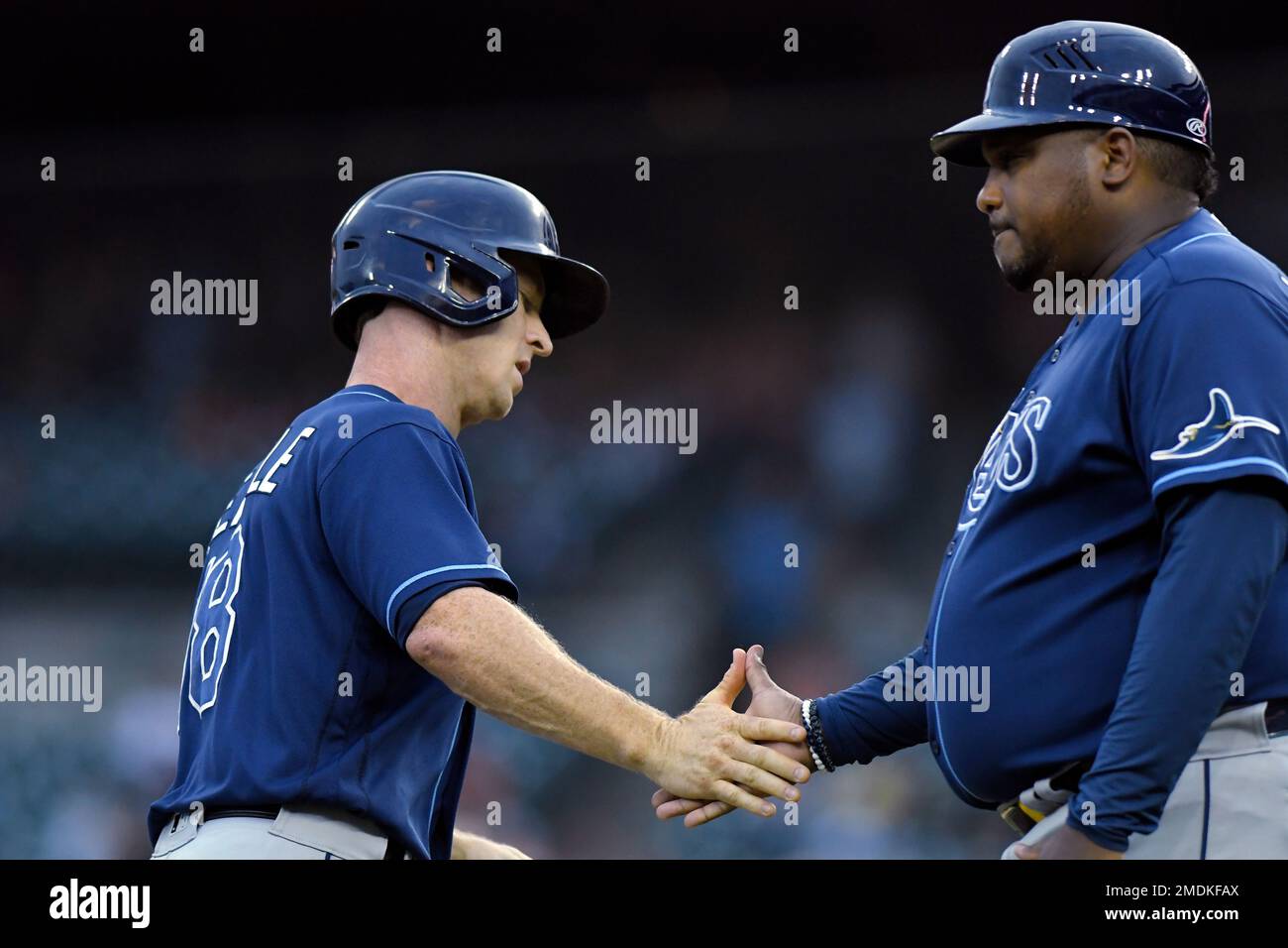 Tampa Bay Rays' Joey Wendle, left, is congratulated by third base coach ...