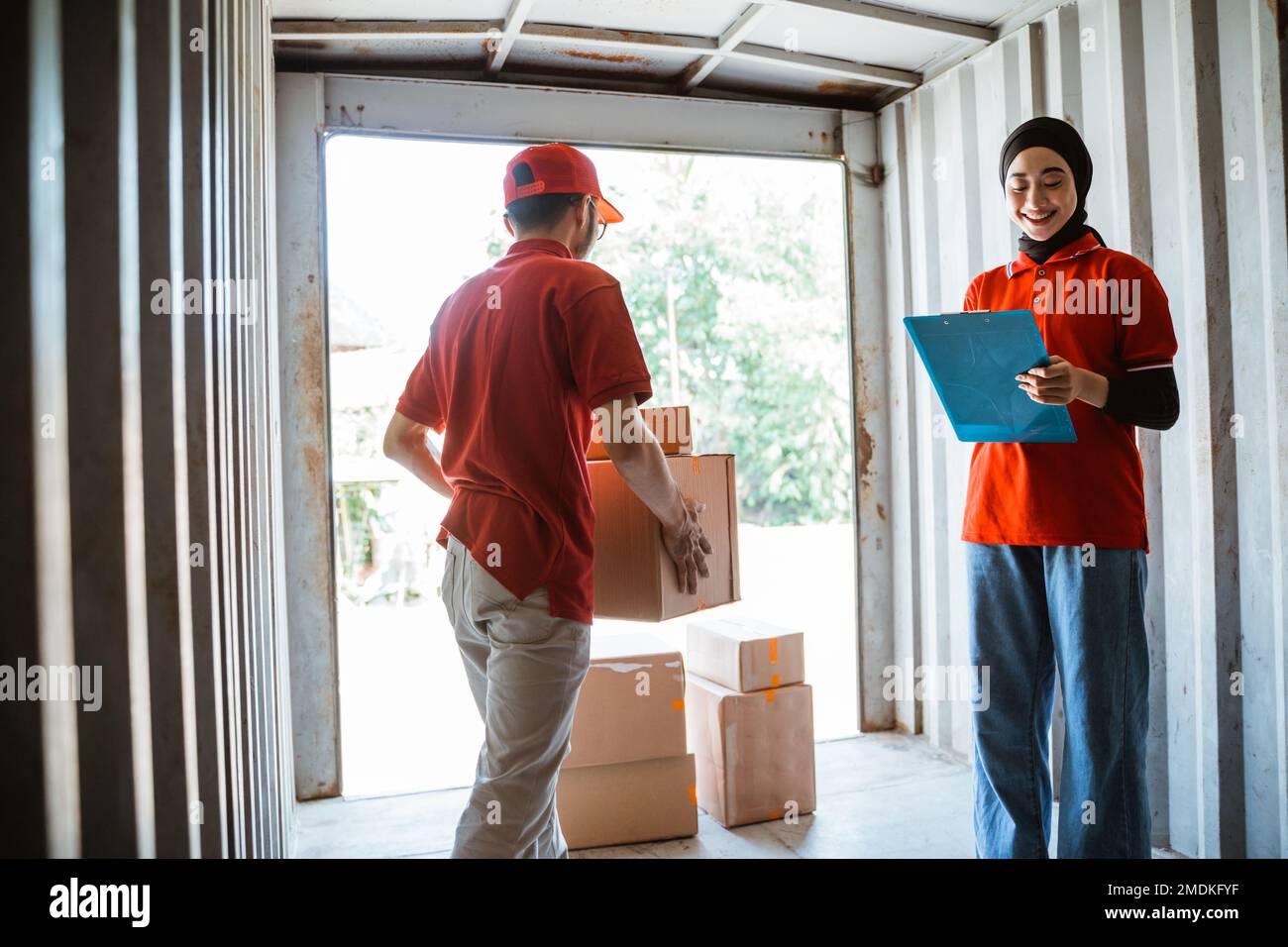 female workers to check and male workers lift boxes Stock Photo - Alamy