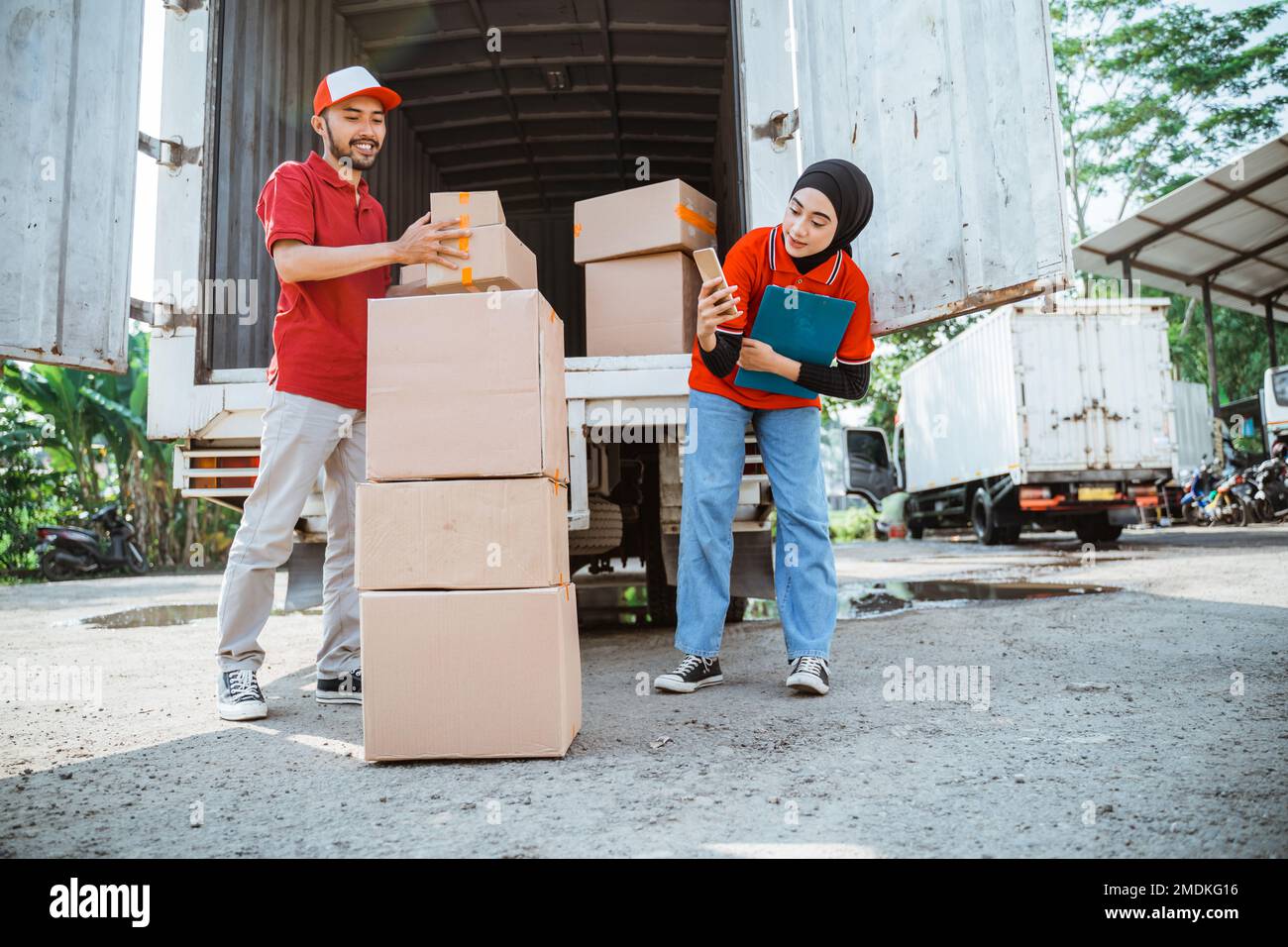 female worker takes photo of delivery man using cell phone Stock Photo ...