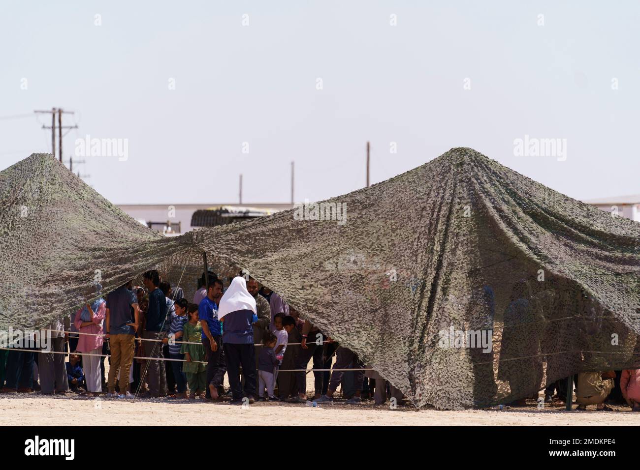 Afghan refugees line up for food outside a dining hall at Fort Bliss ...