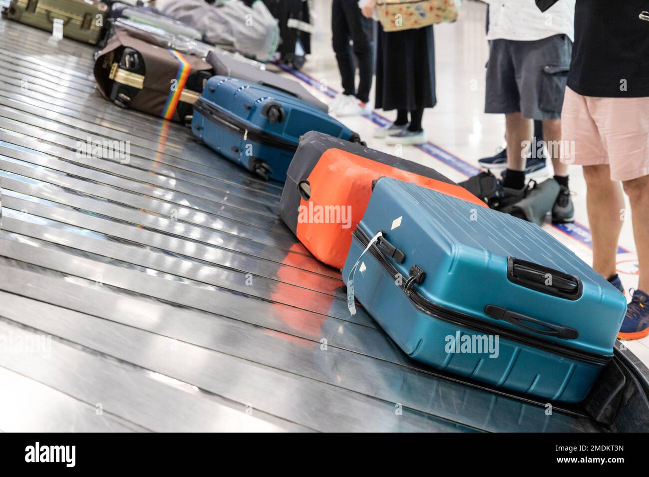 Baggage luggage at airport arrival carousel with passengers awiating to ...
